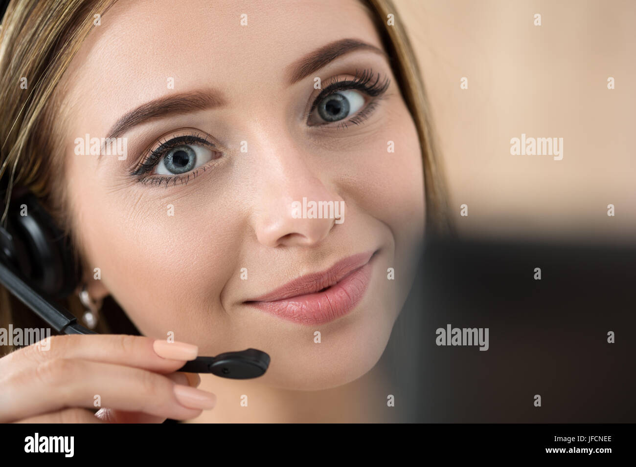 Portrait of beautiful call center operator at work. Woman with headset talking to someone online ...