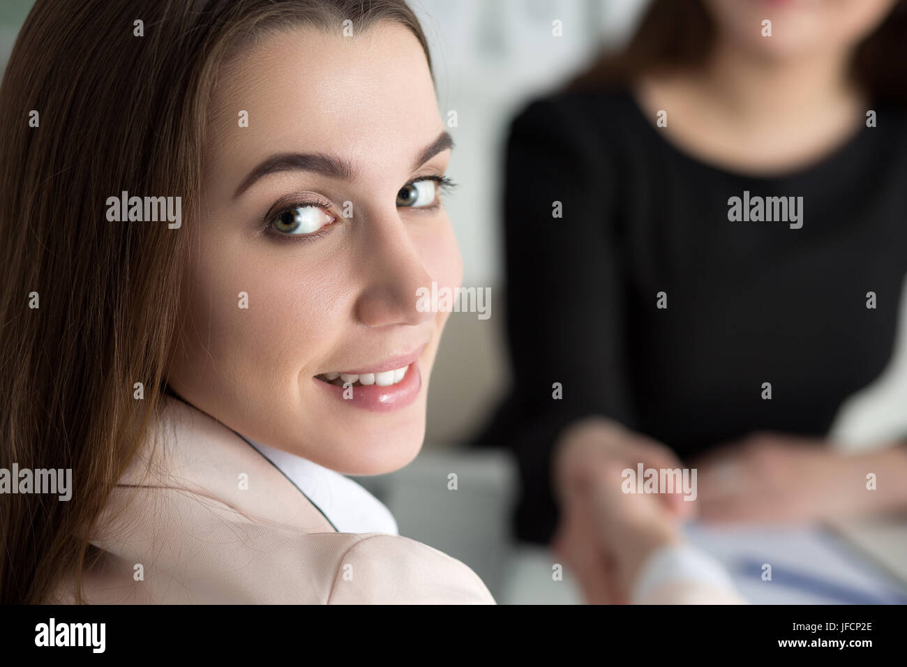 Two women handshake in office. Businesswomen shaking hands. Lady looks ...