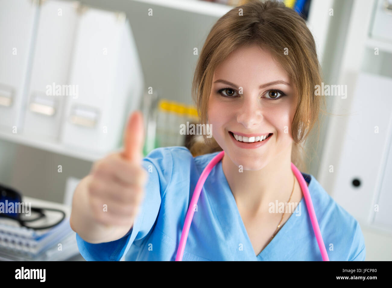 Smiling female medicine doctor showing ok or approval sign with thumb ...