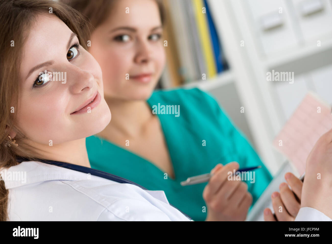 Two beautiful female medicine doctors working at their office ...