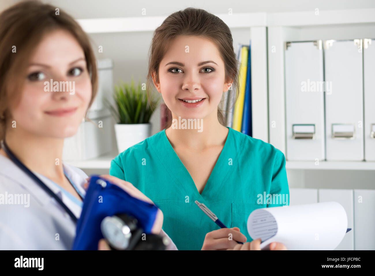 Two beautiful female medicine doctors working at their office ...
