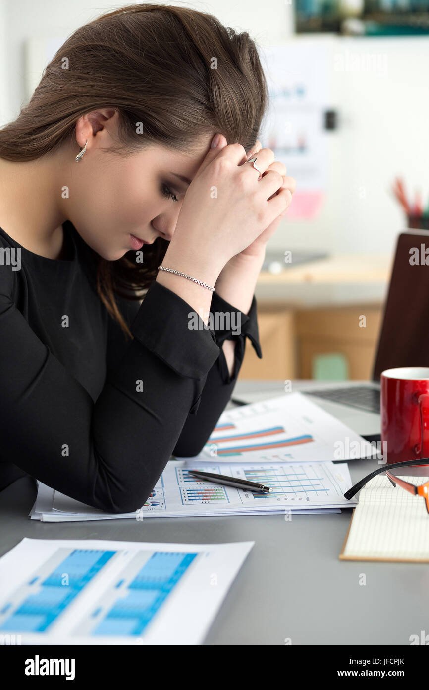 Tired female employee at workplace in office touching her head. Sleepy ...