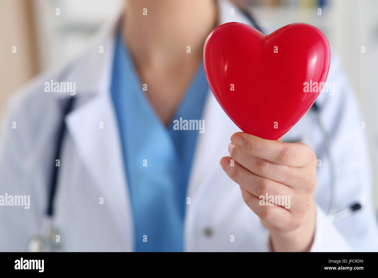 Female medicine doctor holds in hands red toy heart closeup. Cardio ...