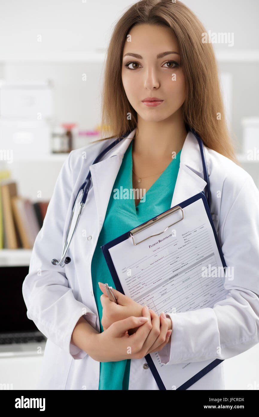 Portrait of female doctor holding clipping pad with patient ...