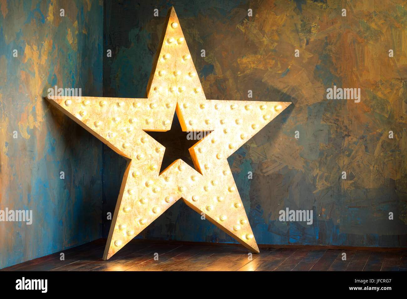 Wooden star with lights standing over rustic wall background Stock ...