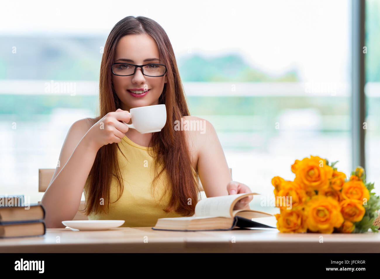 Young student drinking coffee while sudying Stock Photo - Alamy