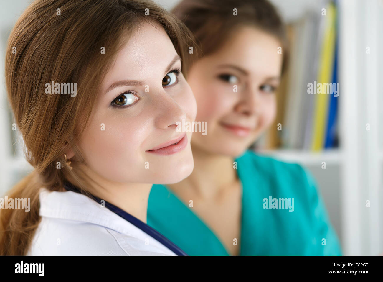 Two beautiful female medicine doctors working at their office ...