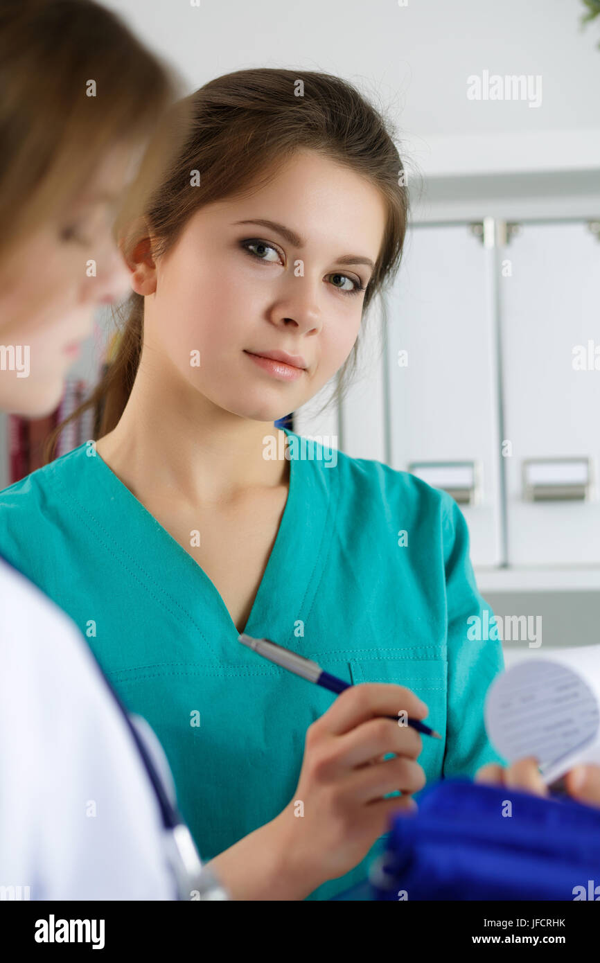 Two beautiful female medicine doctors working at their office ...