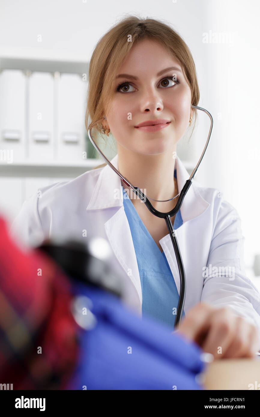 Smiling female medicine doctor measuring blood pressure to patient ...