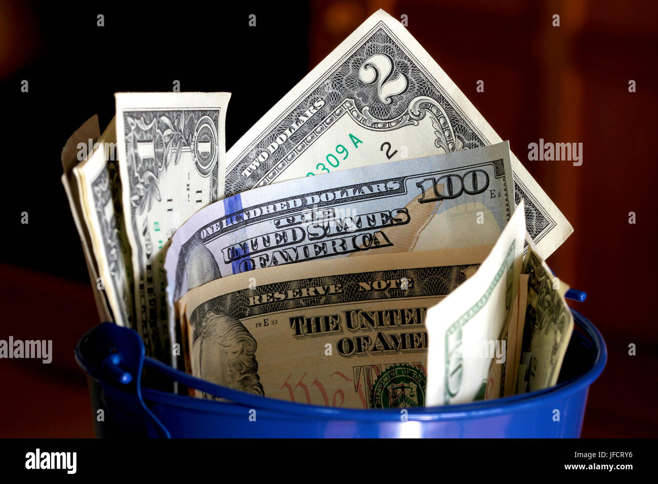 American money in a blue bucket Stock Photo - Alamy