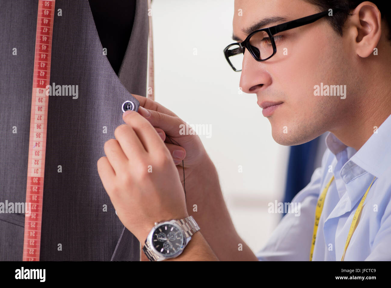 Young man tailor working on new clothing Stock Photo - Alamy