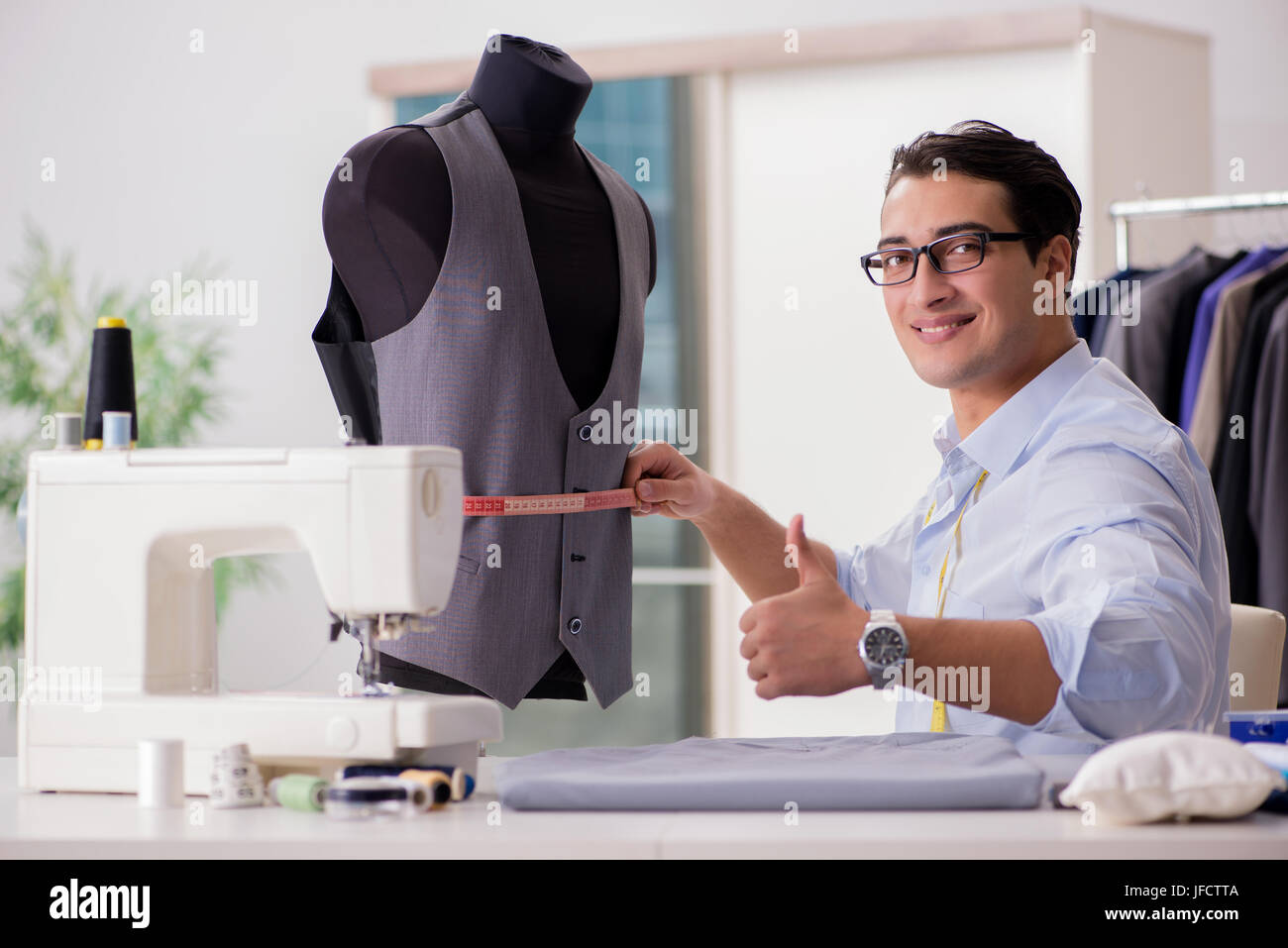 Young man tailor working on new clothing Stock Photo - Alamy