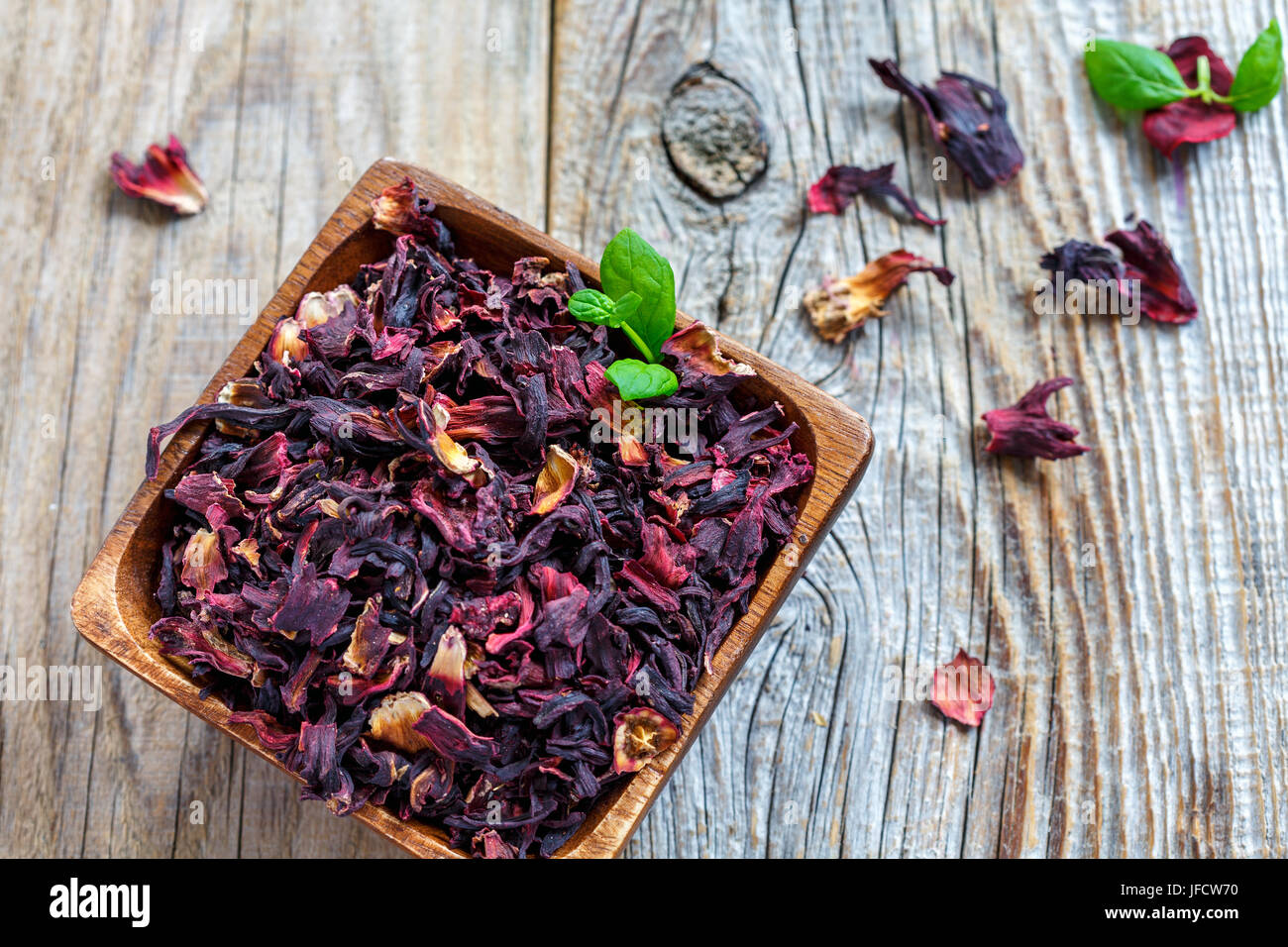 Red Hibiscus tea in a square wooden bowl Stock Photo - Alamy