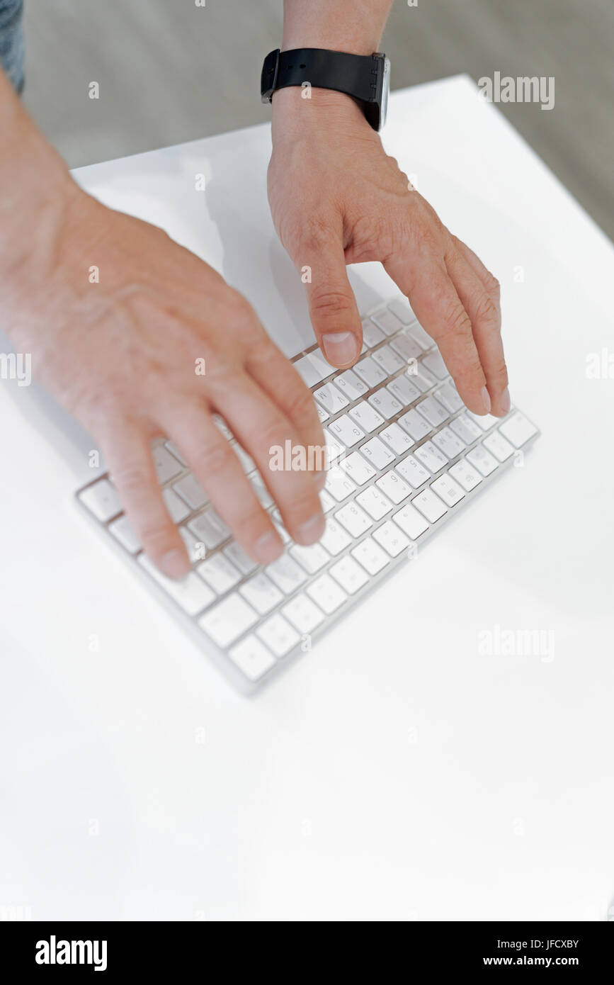Typing and testing. Scaled up shot of adult male hands with a wrist ...