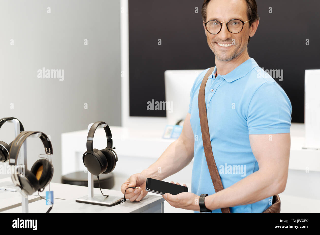 What a perfect pair of headphones. Positive man grinning widely while ...