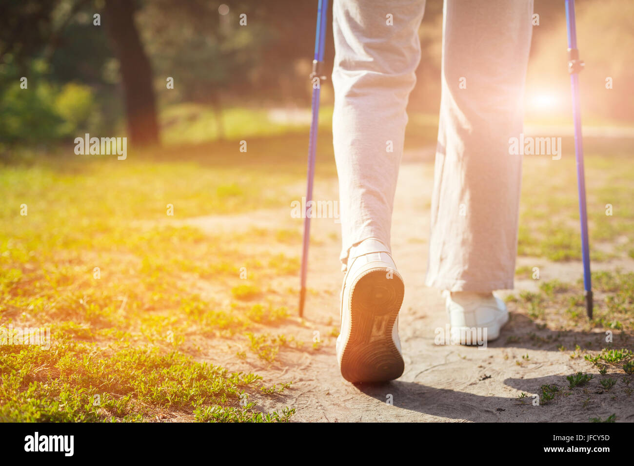 Key to health. Sporty active nice person walking along the footpath and ...