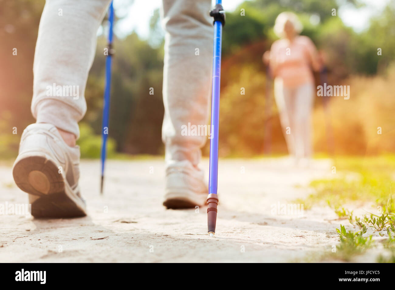 Moving forward. Close up of a walking pole being stuck into the ground ...
