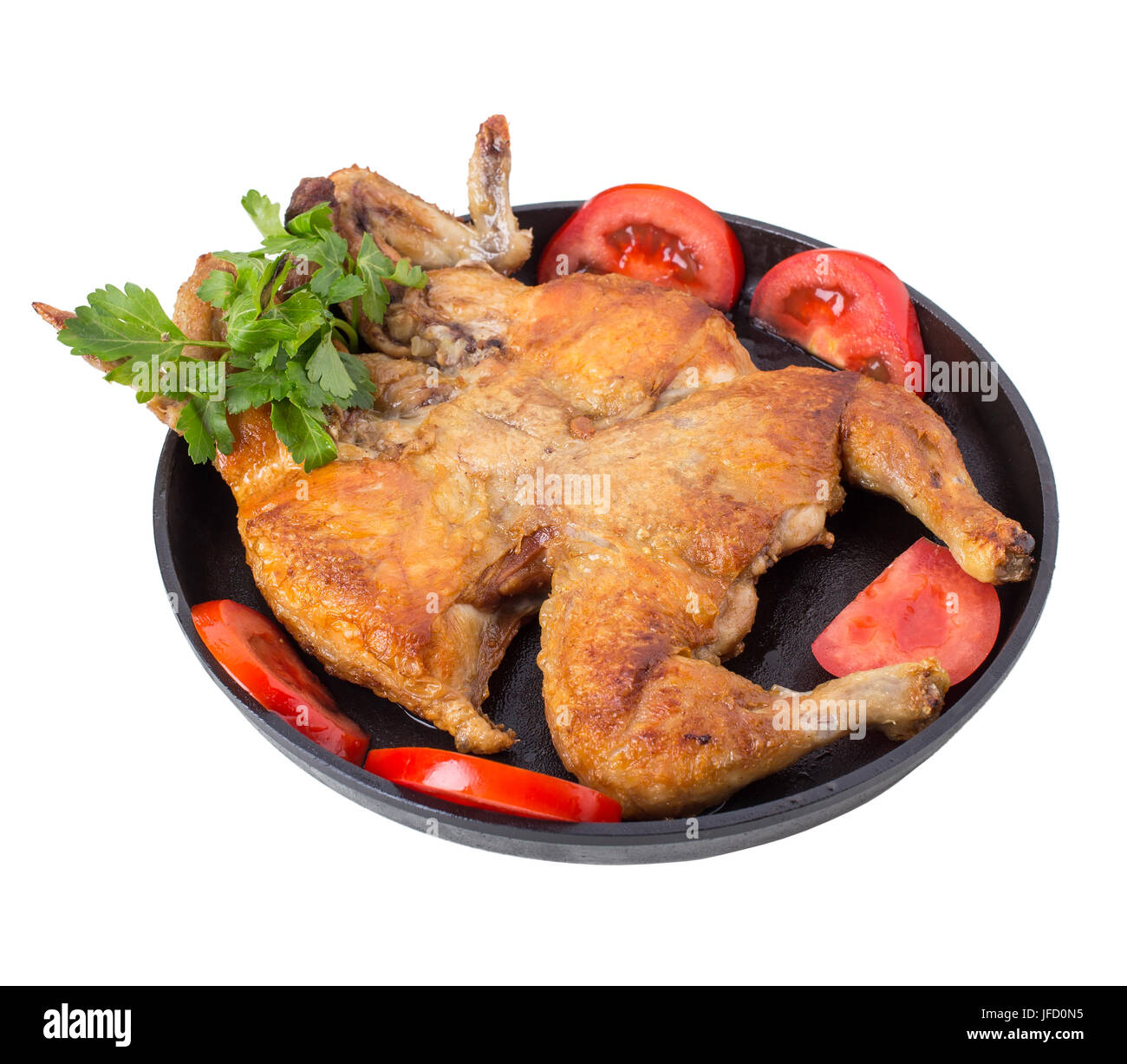 Delicious grilled tabaka chicken with tomatoes on frying pan. Isolated ...