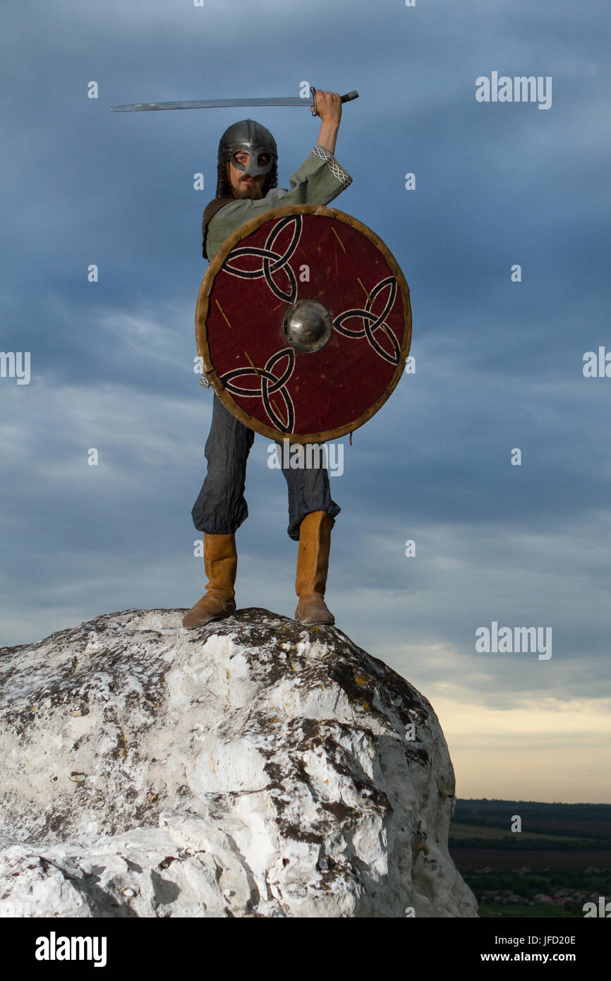 Knight on a rock with a sword Stock Photo - Alamy