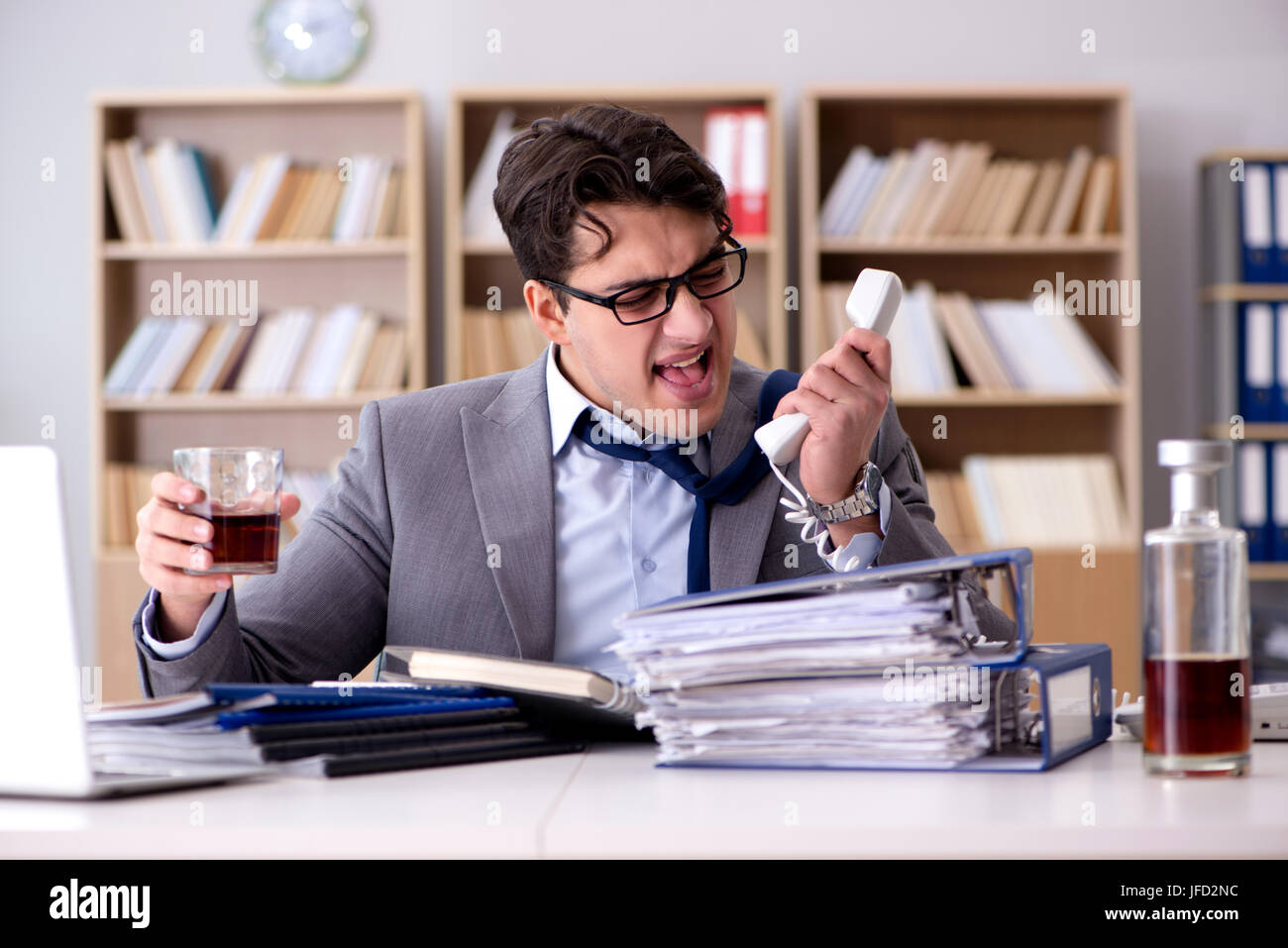 Young businessman drinking from stress Stock Photo - Alamy