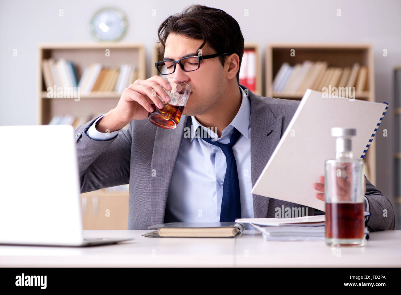Young businessman drinking from stress Stock Photo - Alamy