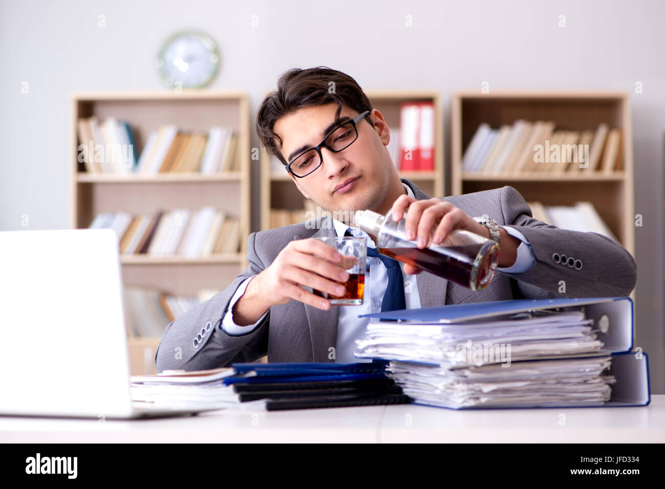 Young businessman drinking from stress Stock Photo - Alamy