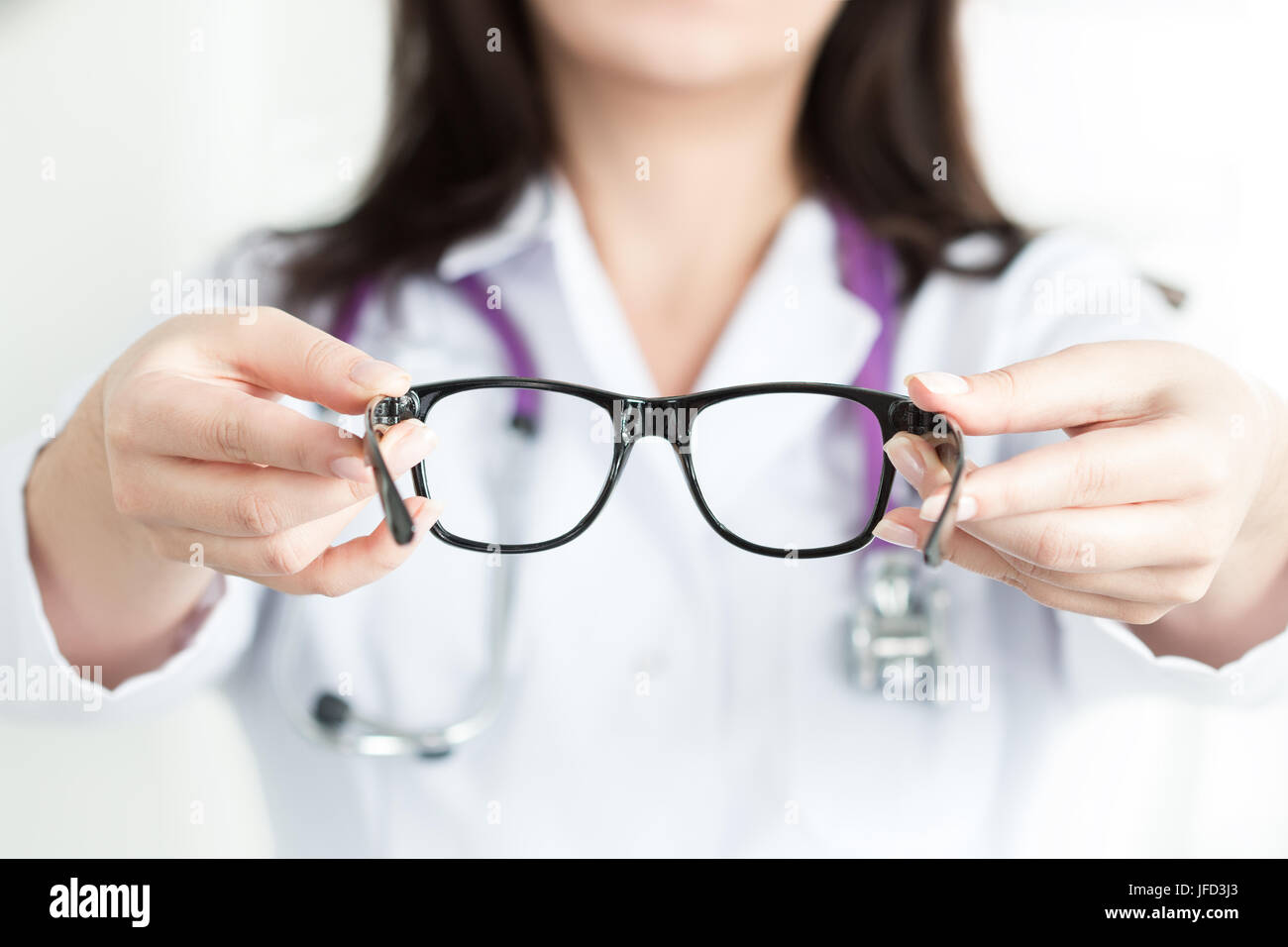 Female oculist doctor's hands giving a pair of black glasses. Good ...