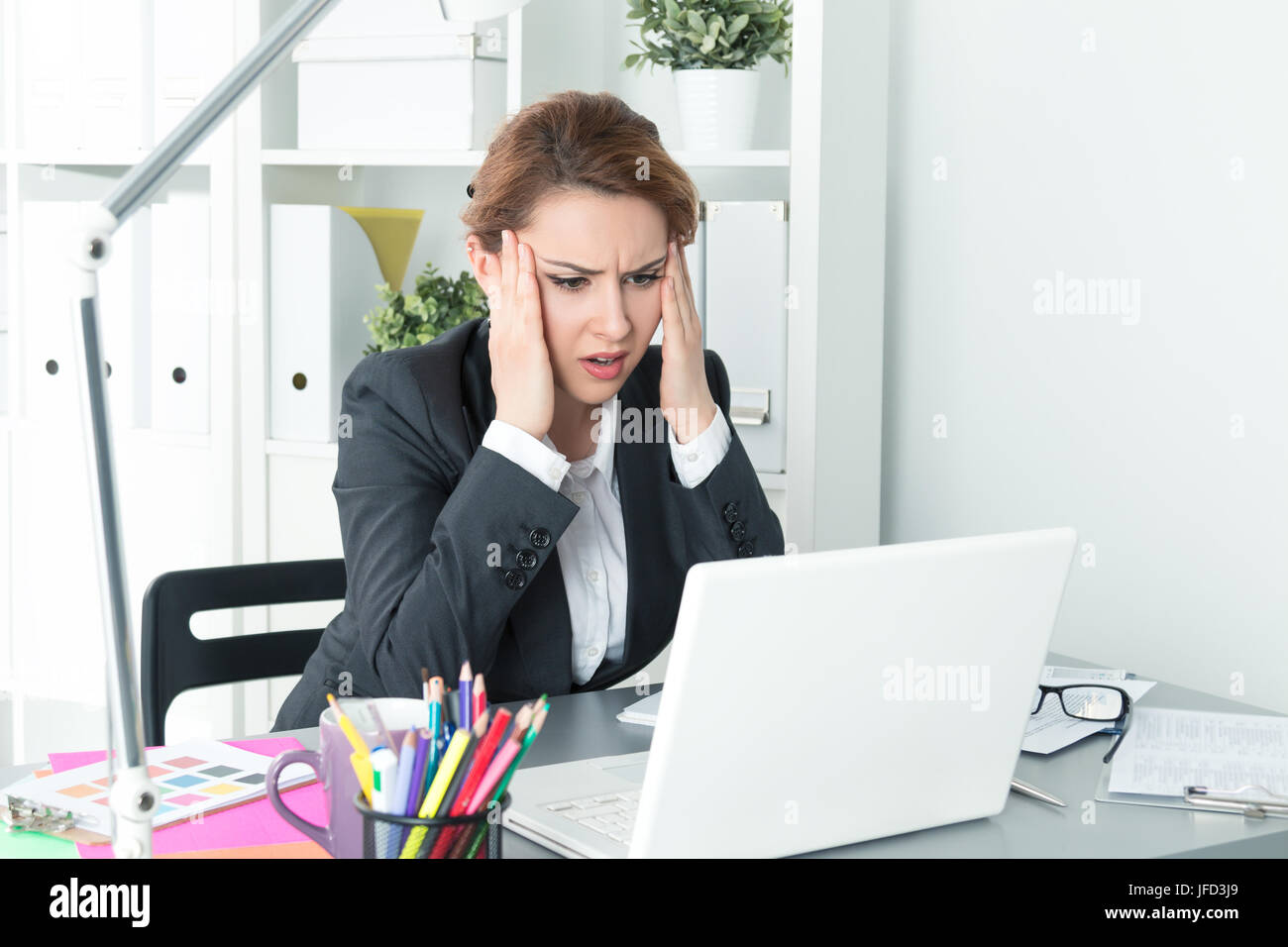 Young beautiful upset business woman trying to concentrate looking at ...