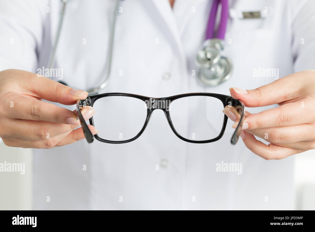 Female oculist doctor's hands giving a pair of black glasses. Good ...