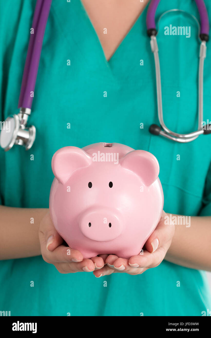 Female Doctor Holding Piggy Bank. Doctor's hands close-up. Medical ...