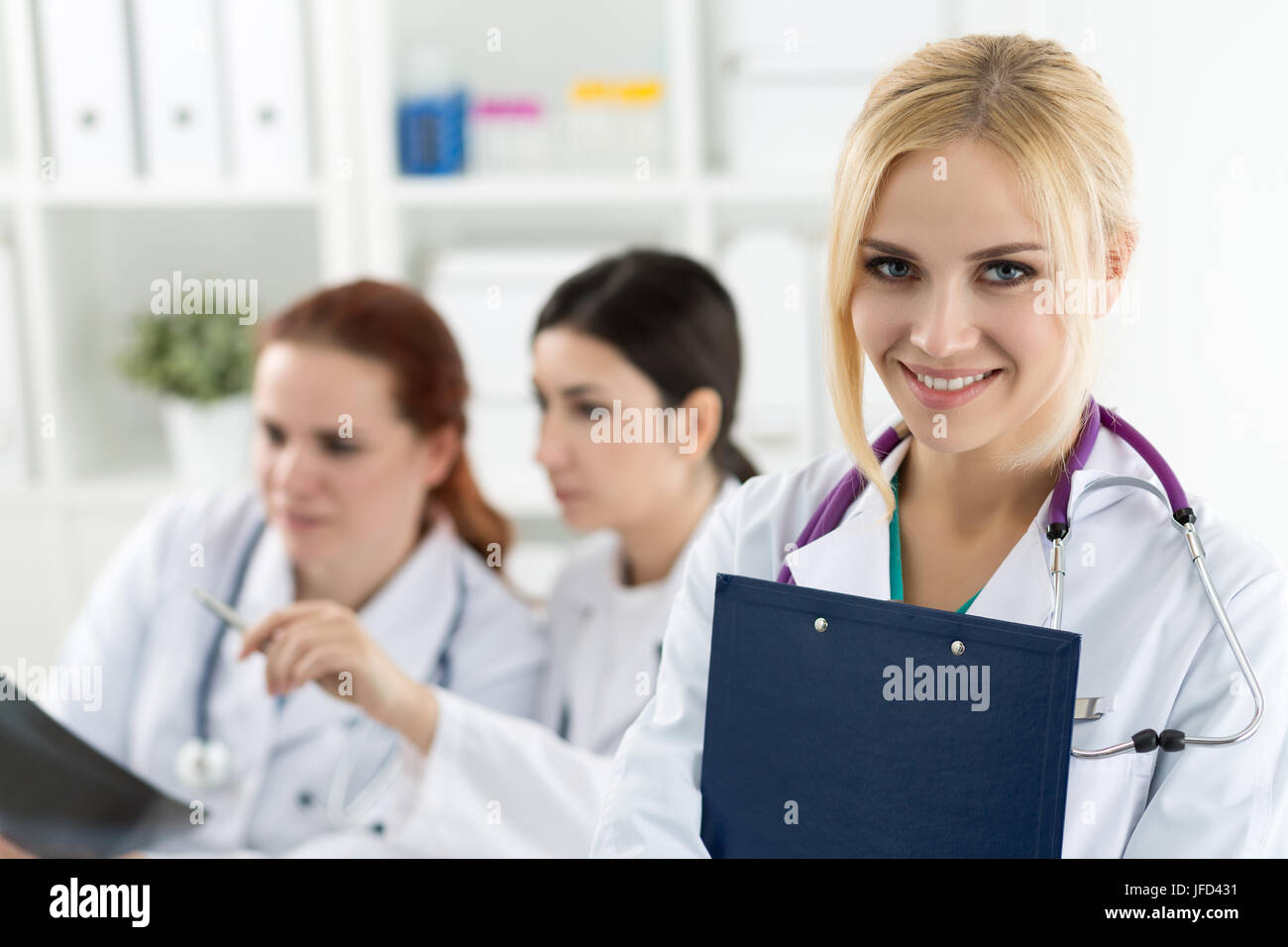 Portrait of smiling female medicine doctor holding blue document folder ...