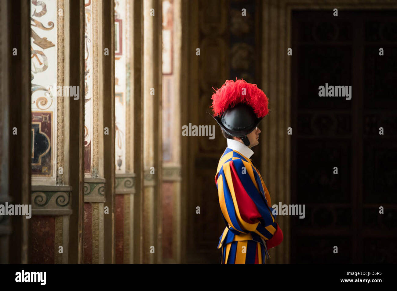 A member of the Pontifical Swiss Guard stands watch in a hallway at the ...