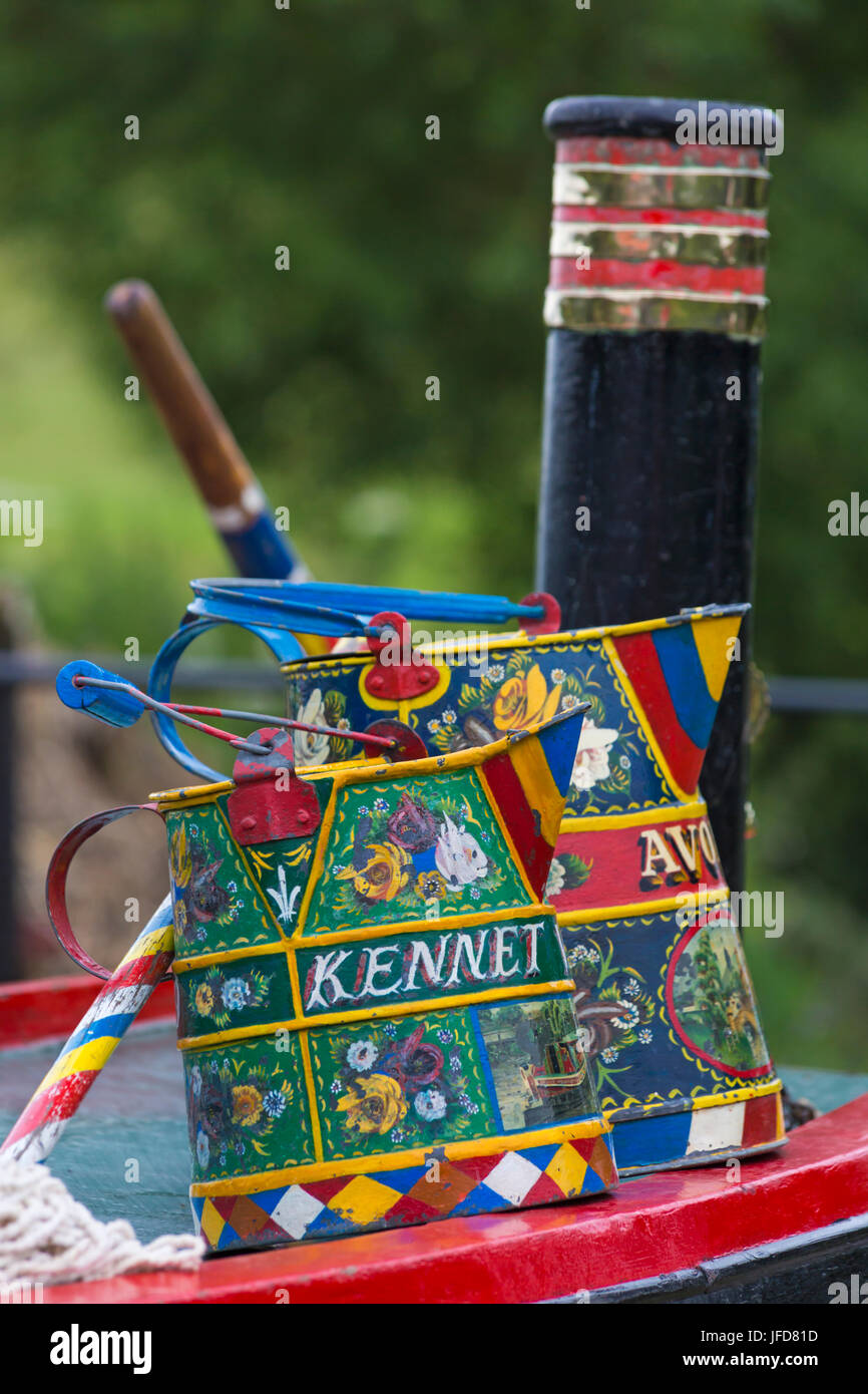 Brightly painted canalware jugs on narrow boat narrowboat barge roof on ...