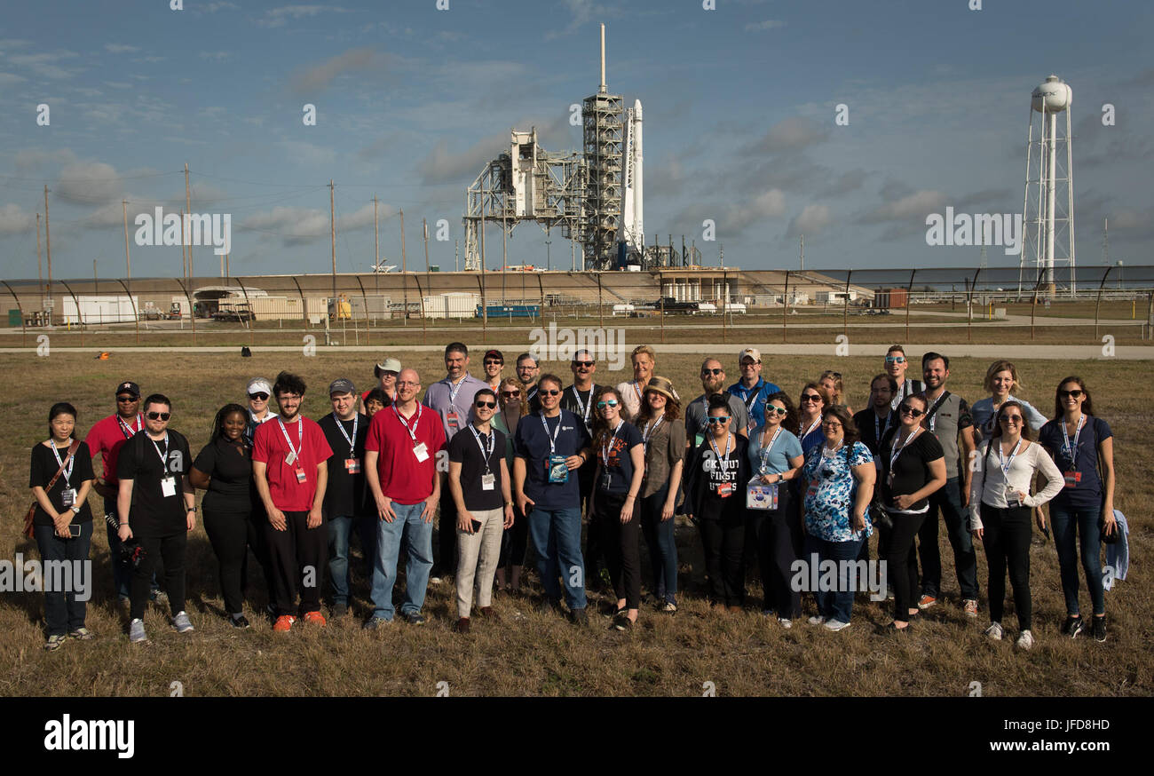 Attendees of a NASA social event pose for a photograph near the SpaceX ...