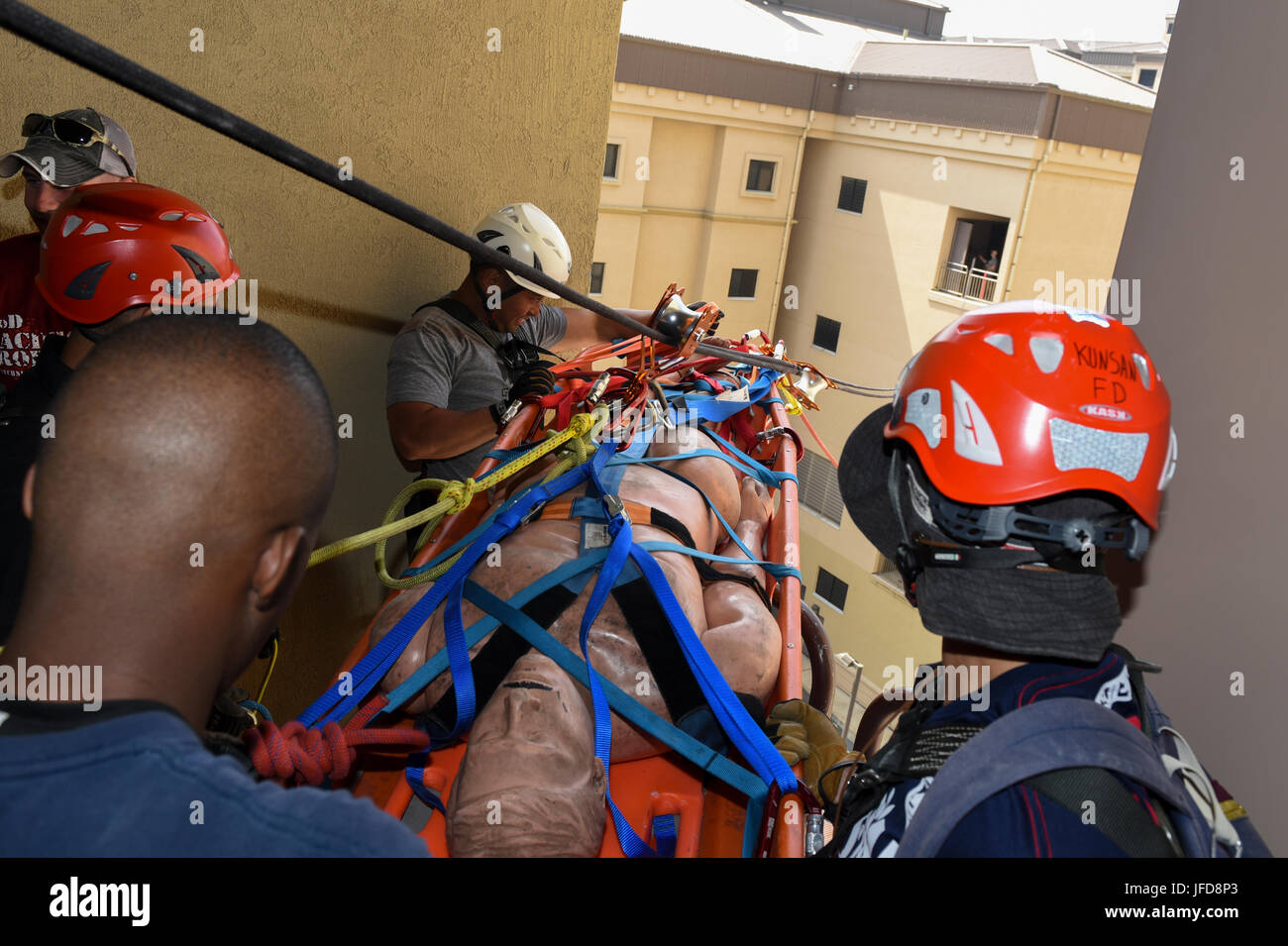 Firefighters from the Pacific Air Forces region raise a Stokes basket ...