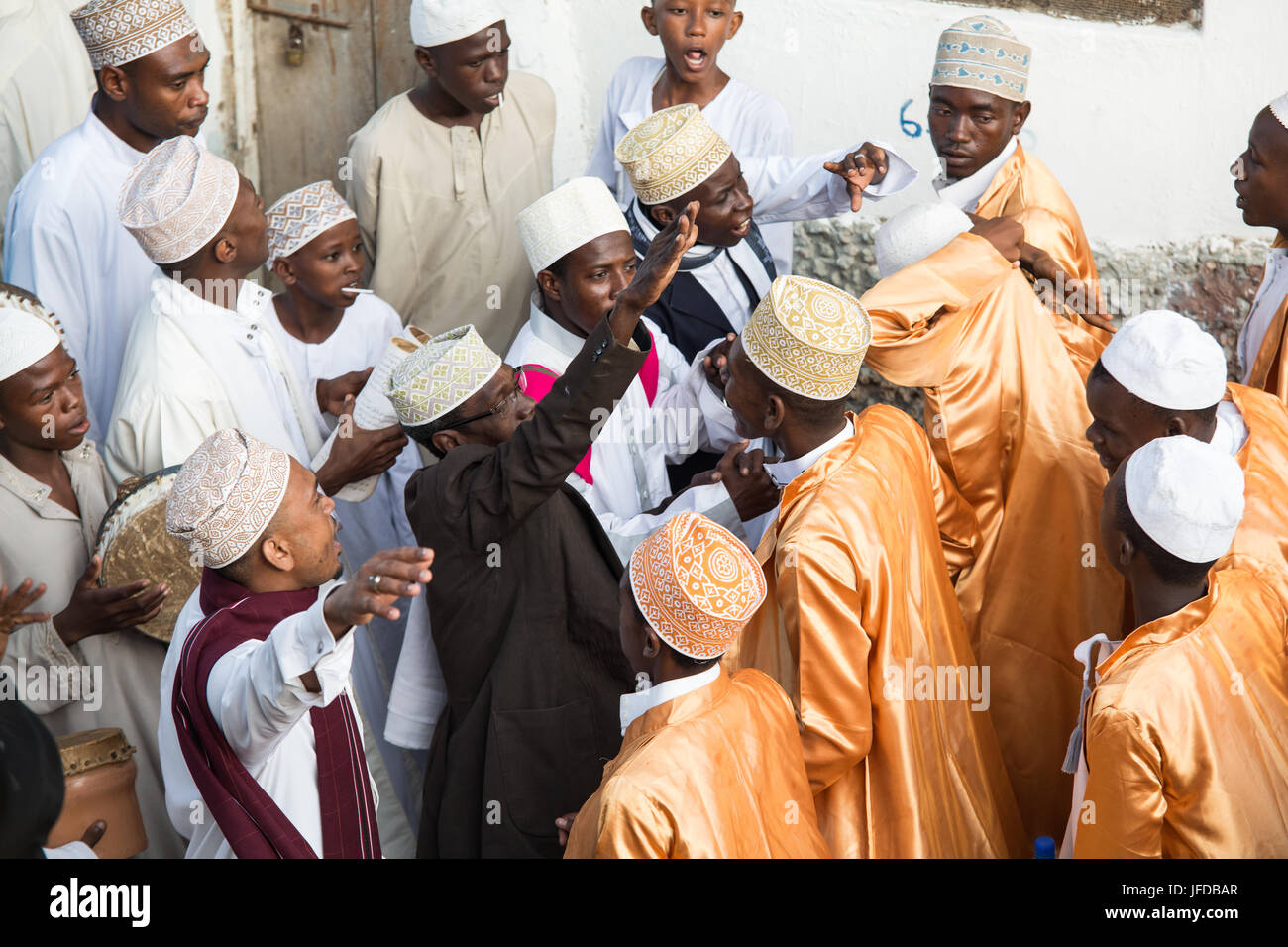 Groups of men and boys celebrate the Zefe procession along the narrow ...