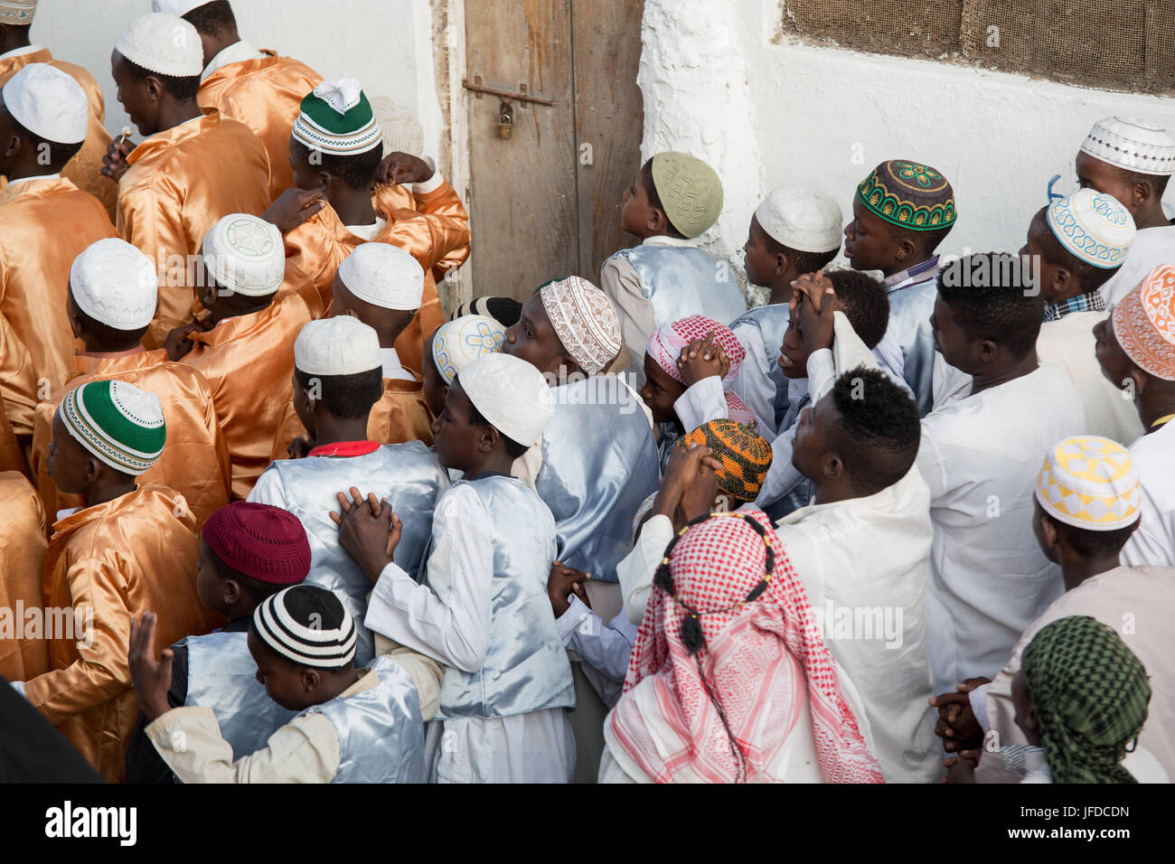Groups of men and boys celebrate the Zefe procession along the narrow ...