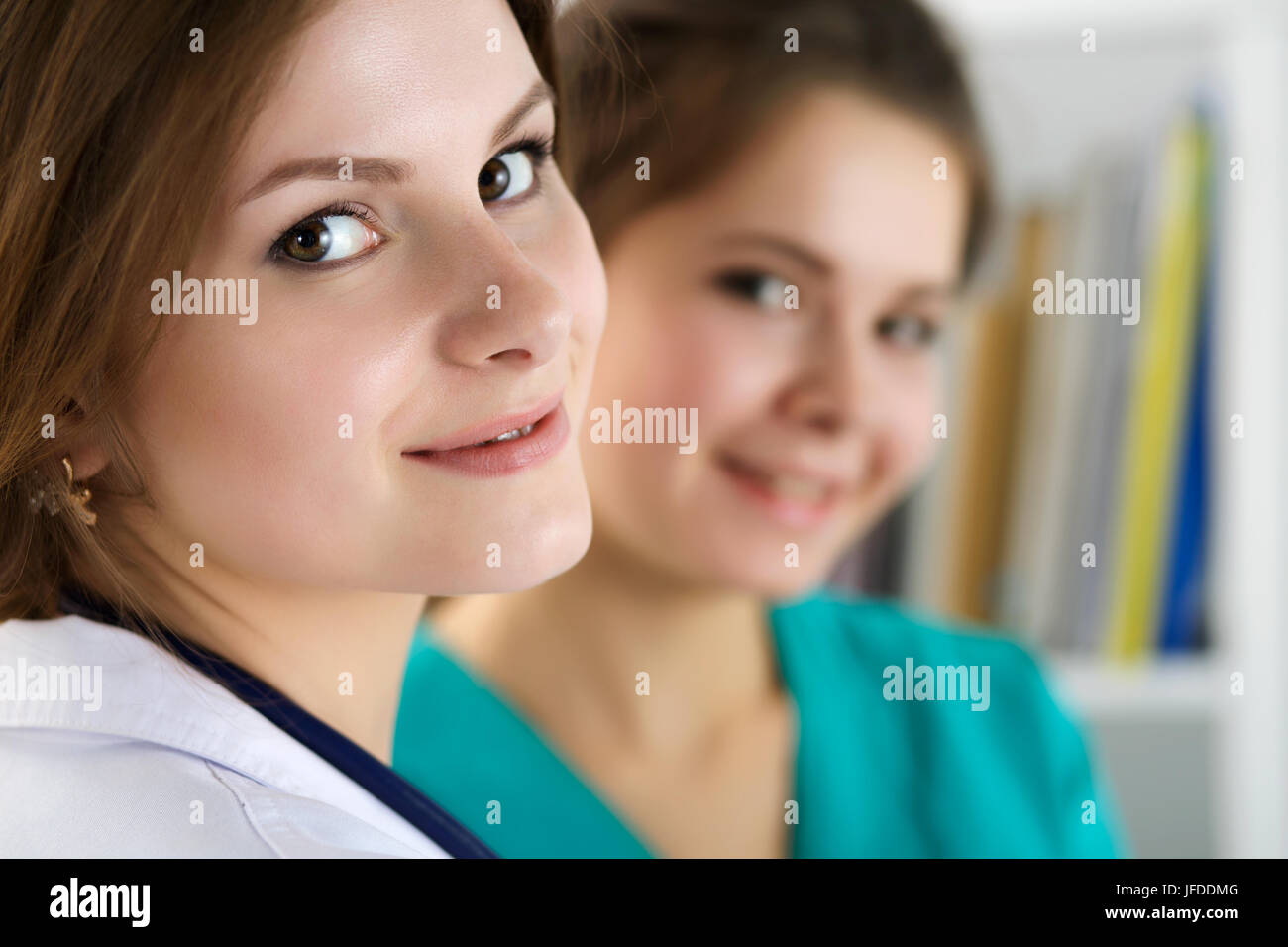 Two beautiful female medicine doctors working at their office ...
