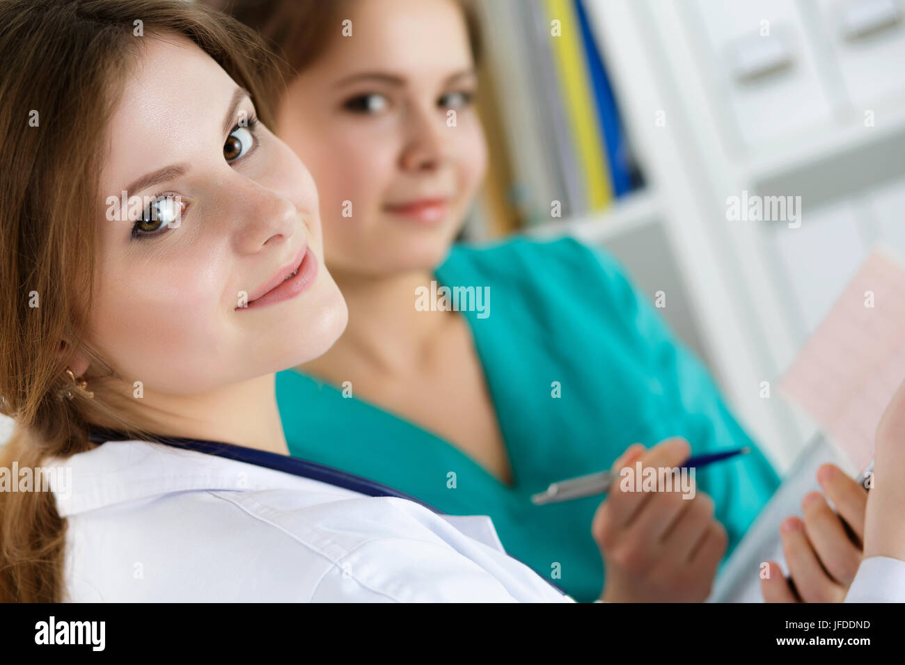 Two beautiful female medicine doctors working at their office ...