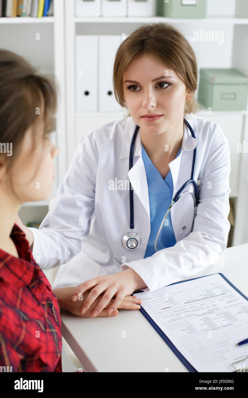 Female doctor touching patient shoulder for encouragement, empathy ...
