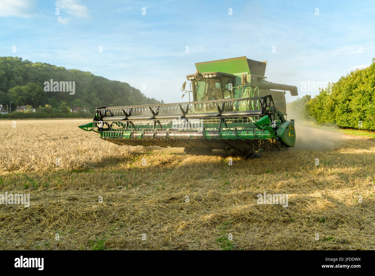 Combine harvester with header raised and turning at the end of a field ...