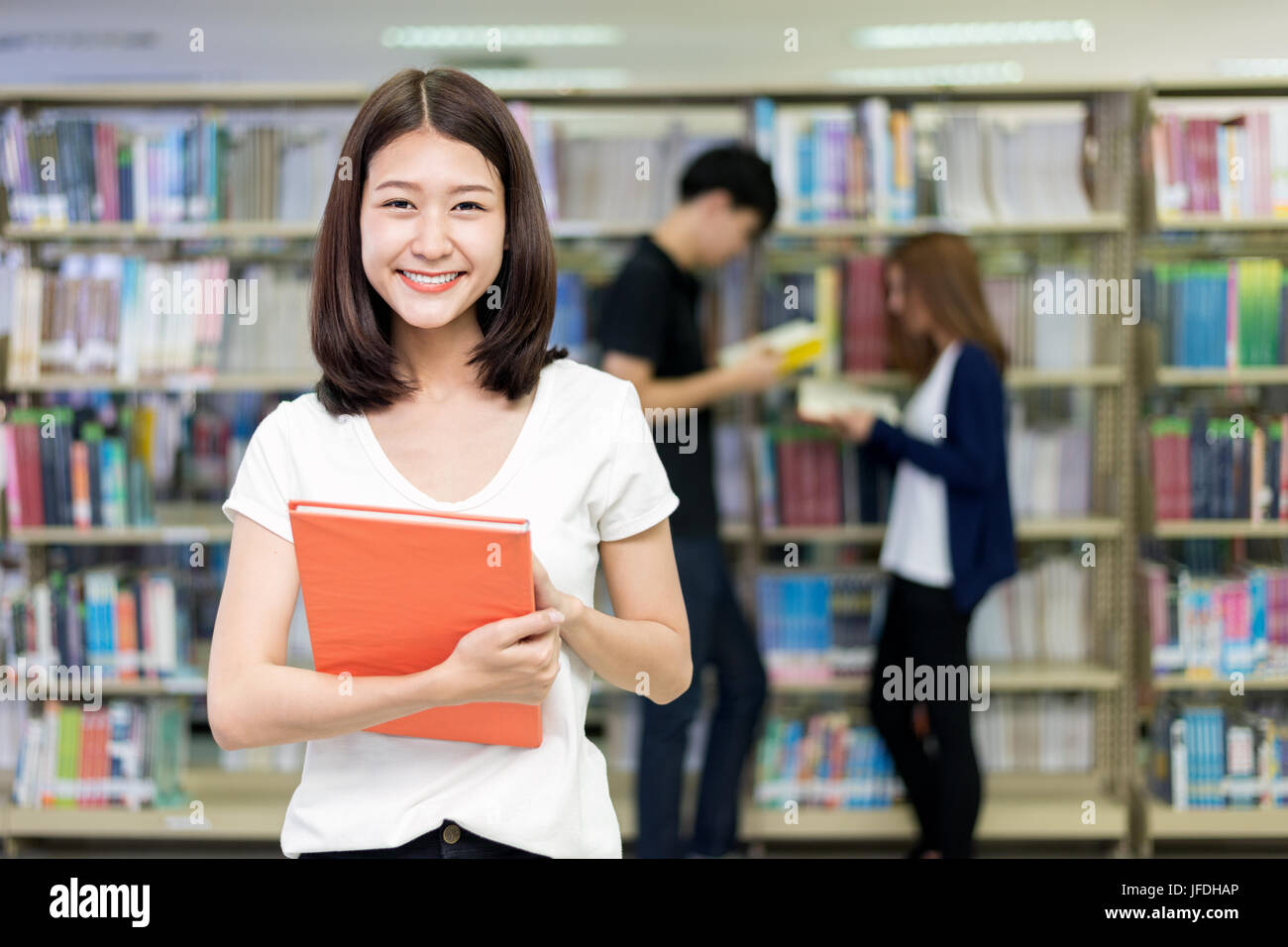 Group of Asian students studying together in library at university ...