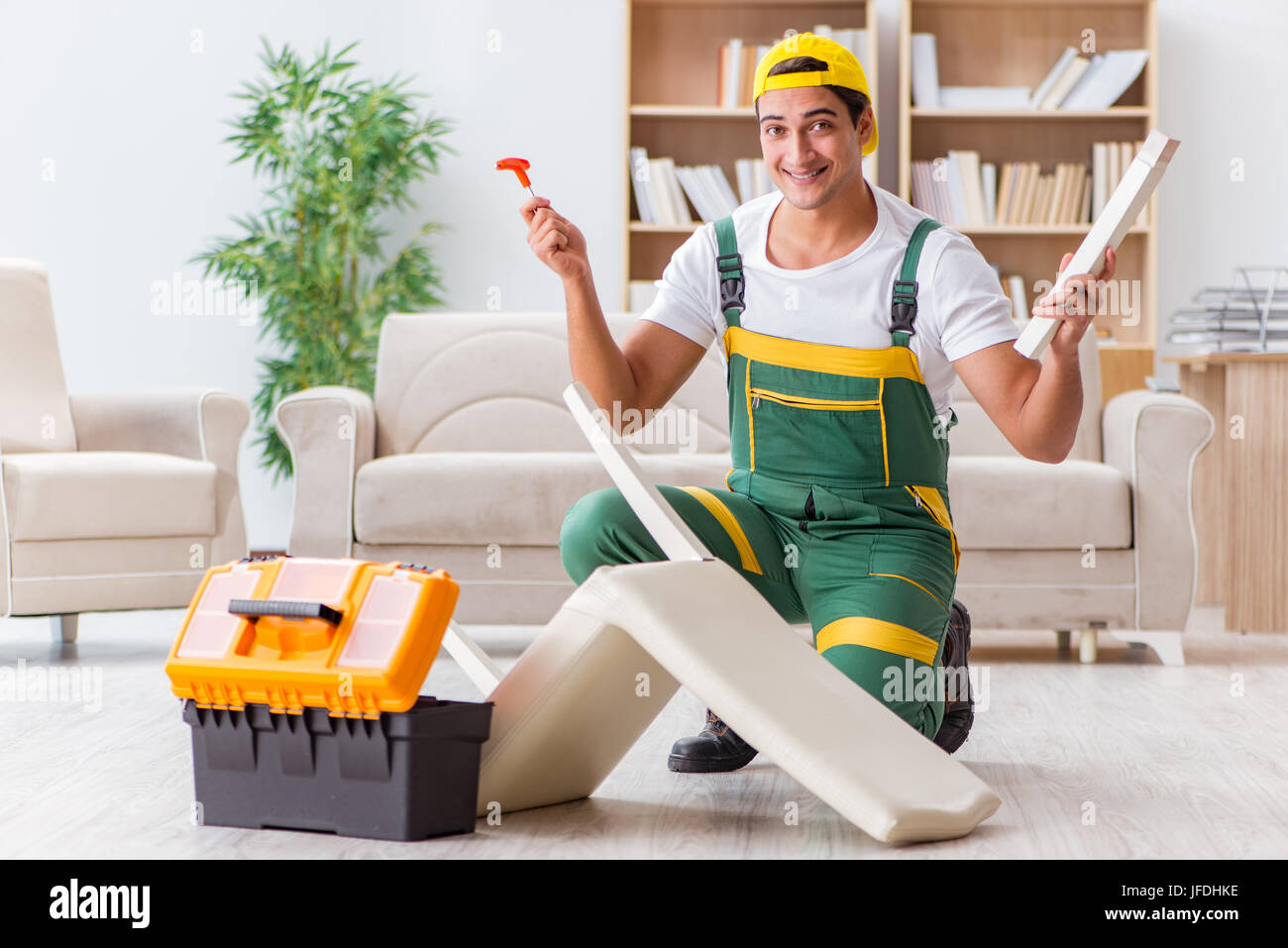 Worker repairing furniture at home Stock Photo - Alamy