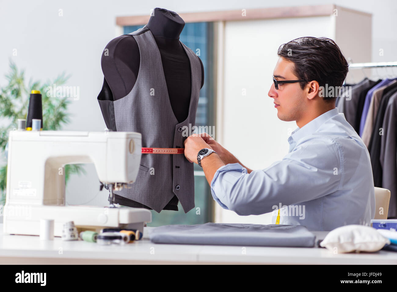 Young man tailor working on new clothing Stock Photo - Alamy