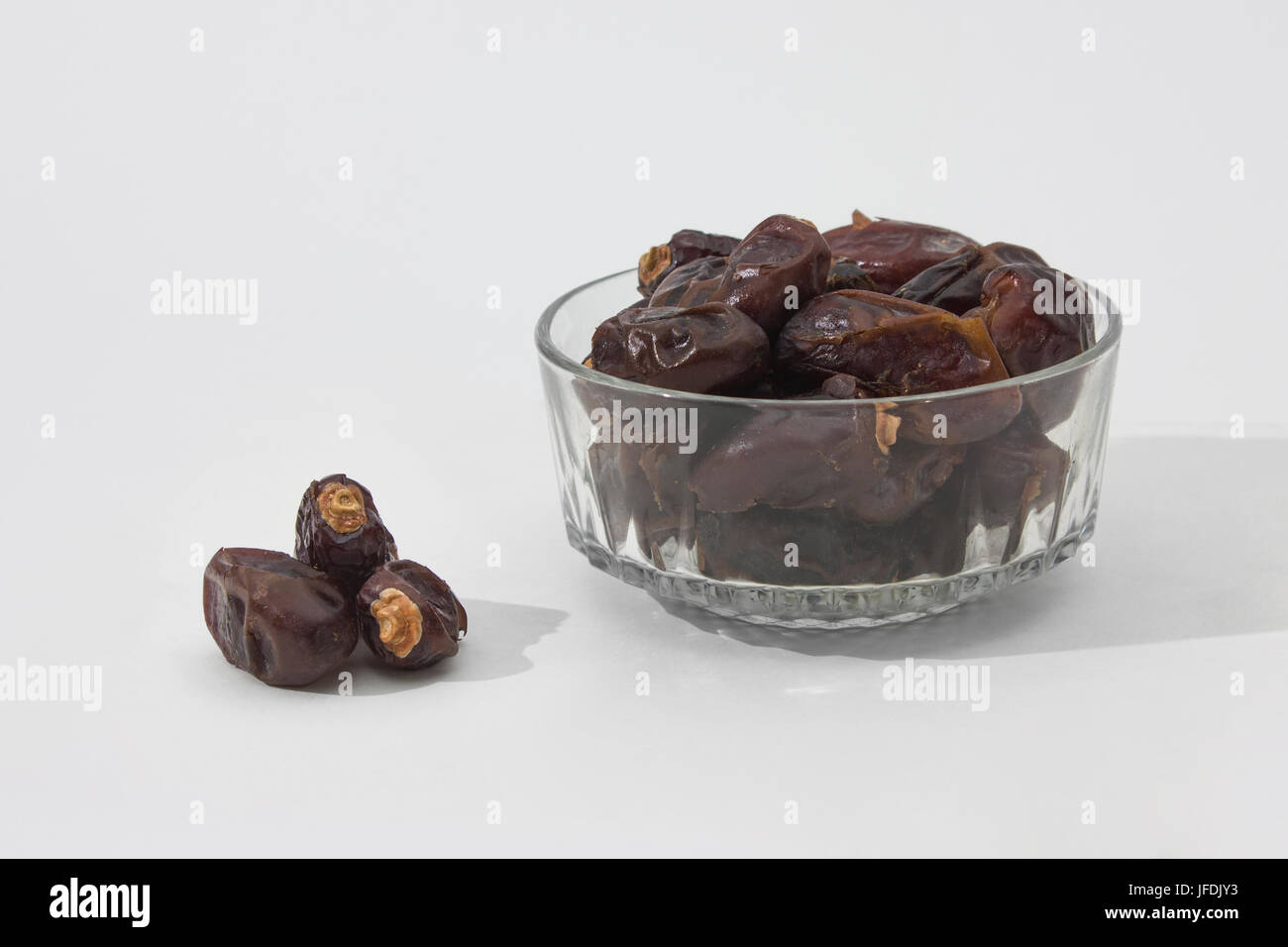 Dates in glass cup isolated on white background Stock Photo - Alamy