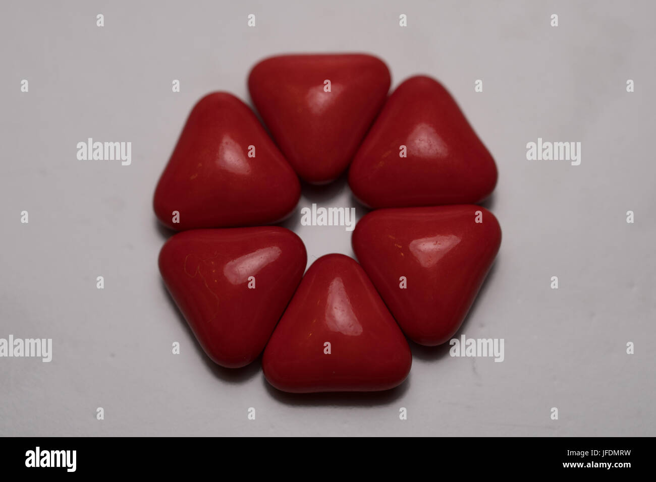 Closeup of red triangle pills looking like heart shaped candy isolated ...