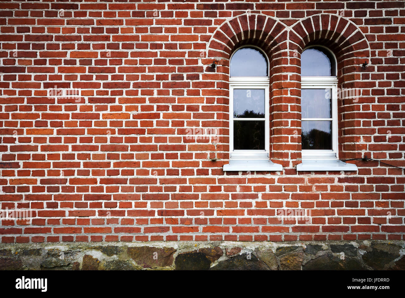 Red brick wall with some windows Stock Photo - Alamy