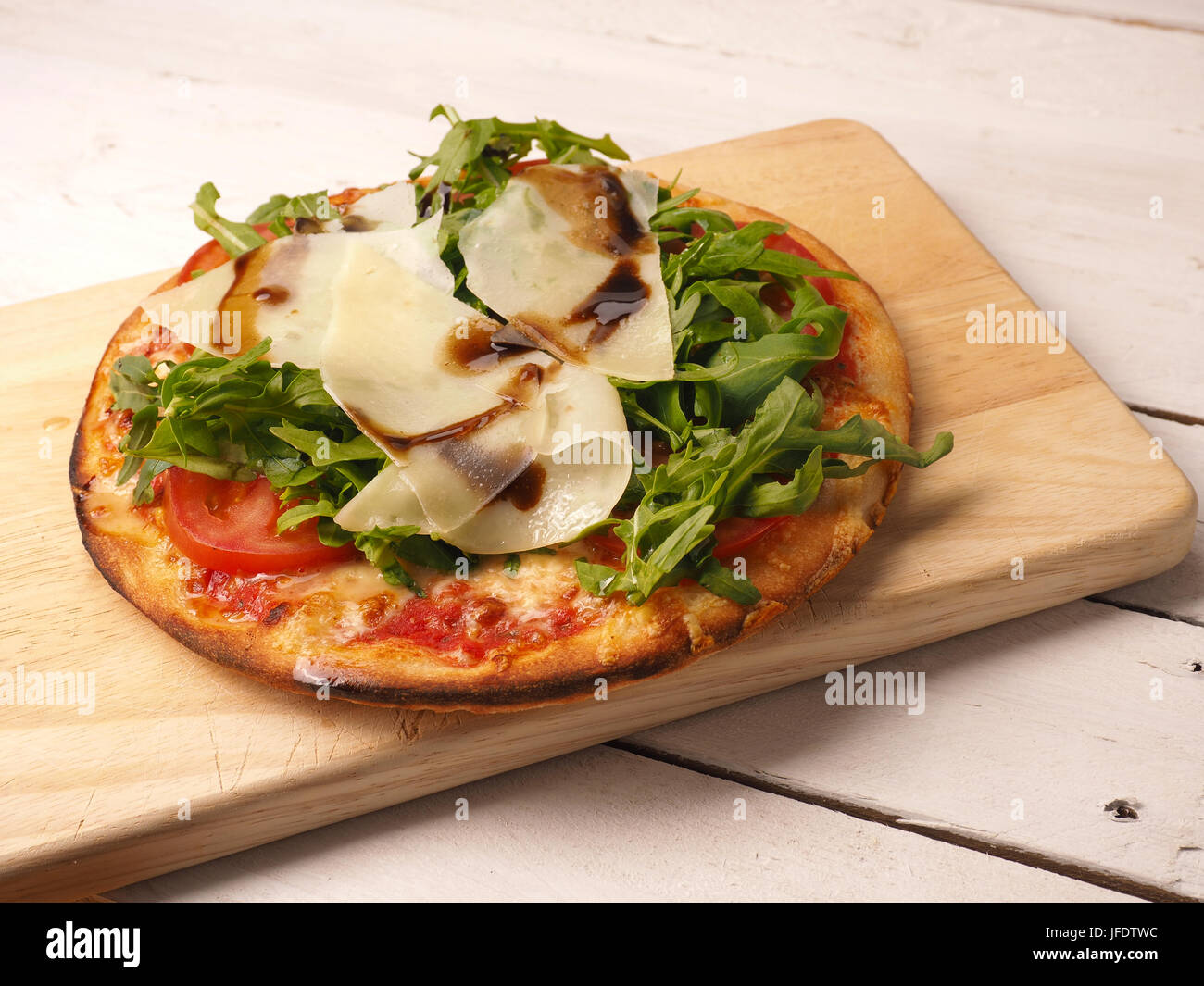 Tasty pizza rucola on a wooden cutting board Stock Photo - Alamy