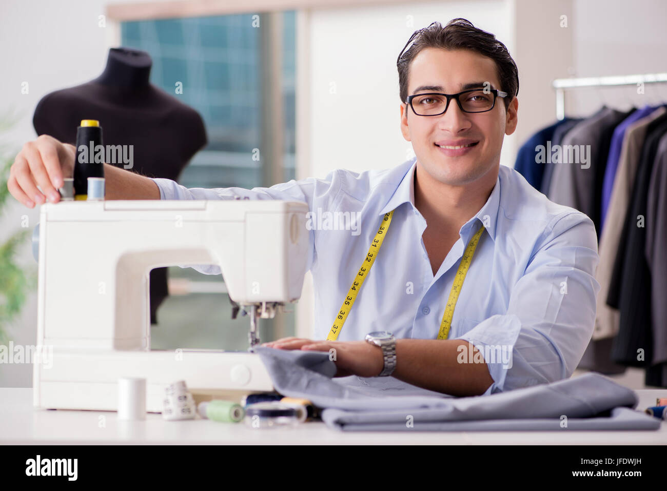 Young man tailor working on new clothing Stock Photo - Alamy