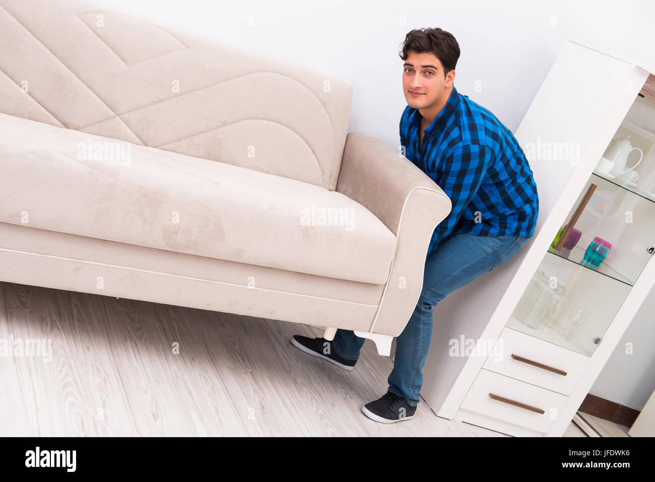 Young man moving sofa couch Stock Photo - Alamy